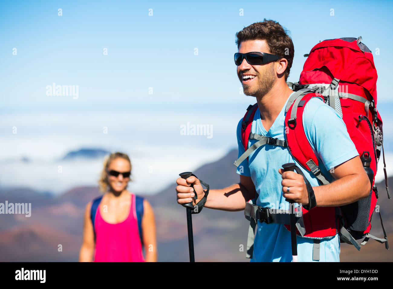 Two hikers relaxing enjoying the amazing view from the mountain top ...