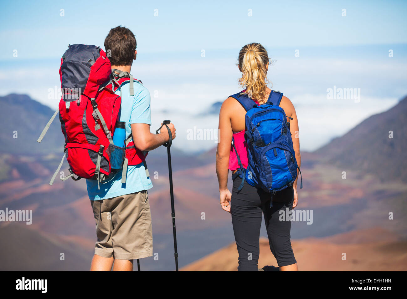 Two hikers relaxing enjoying the amazing view from the mountain top ...