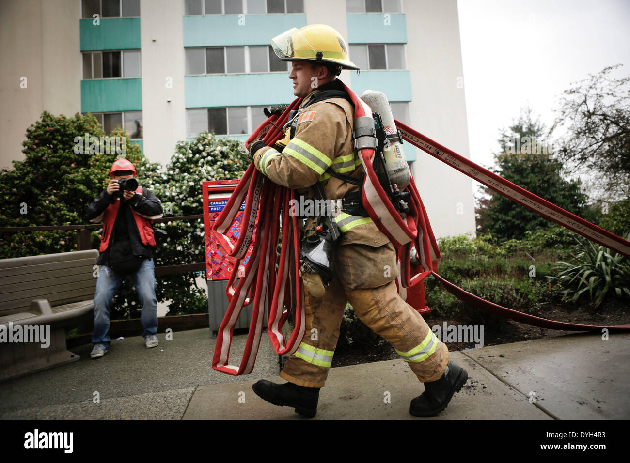 Vancouver, Canada. 17th Apr, 2014. A firefighter carries fire hose into ...
