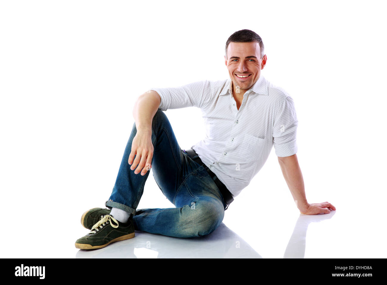 Happy man sitting at the floor over white background Stock Photo - Alamy