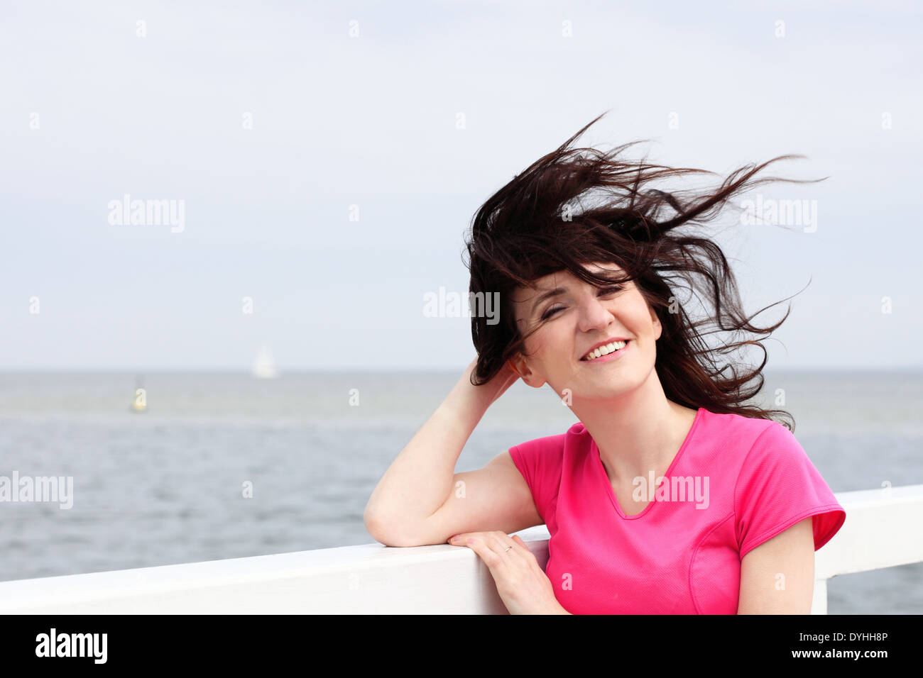 Woman at the seaside, on the beach on a windy day Stock Photo - Alamy