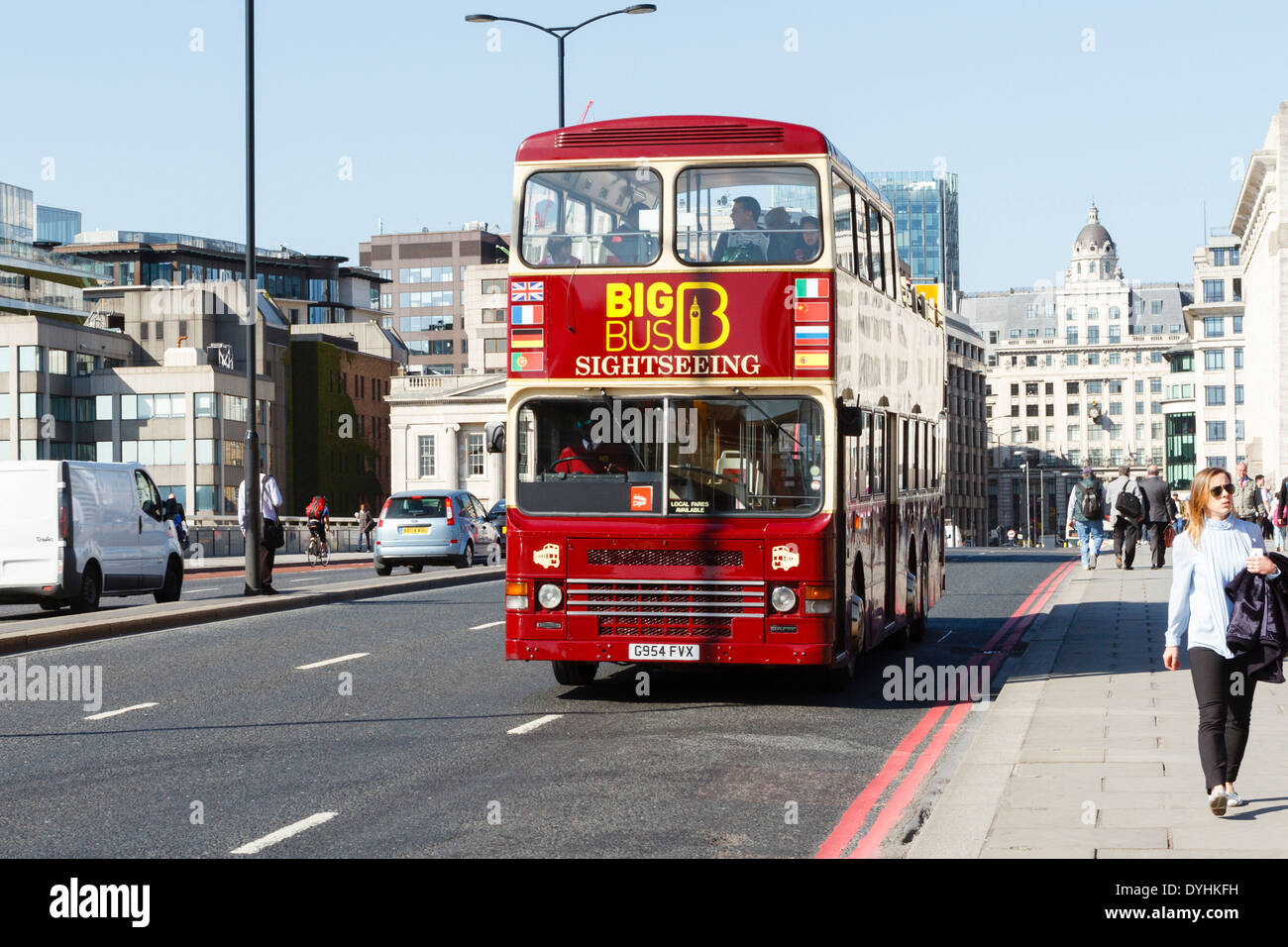 Open top tour bus with passengers passing over London Bridge, England ...