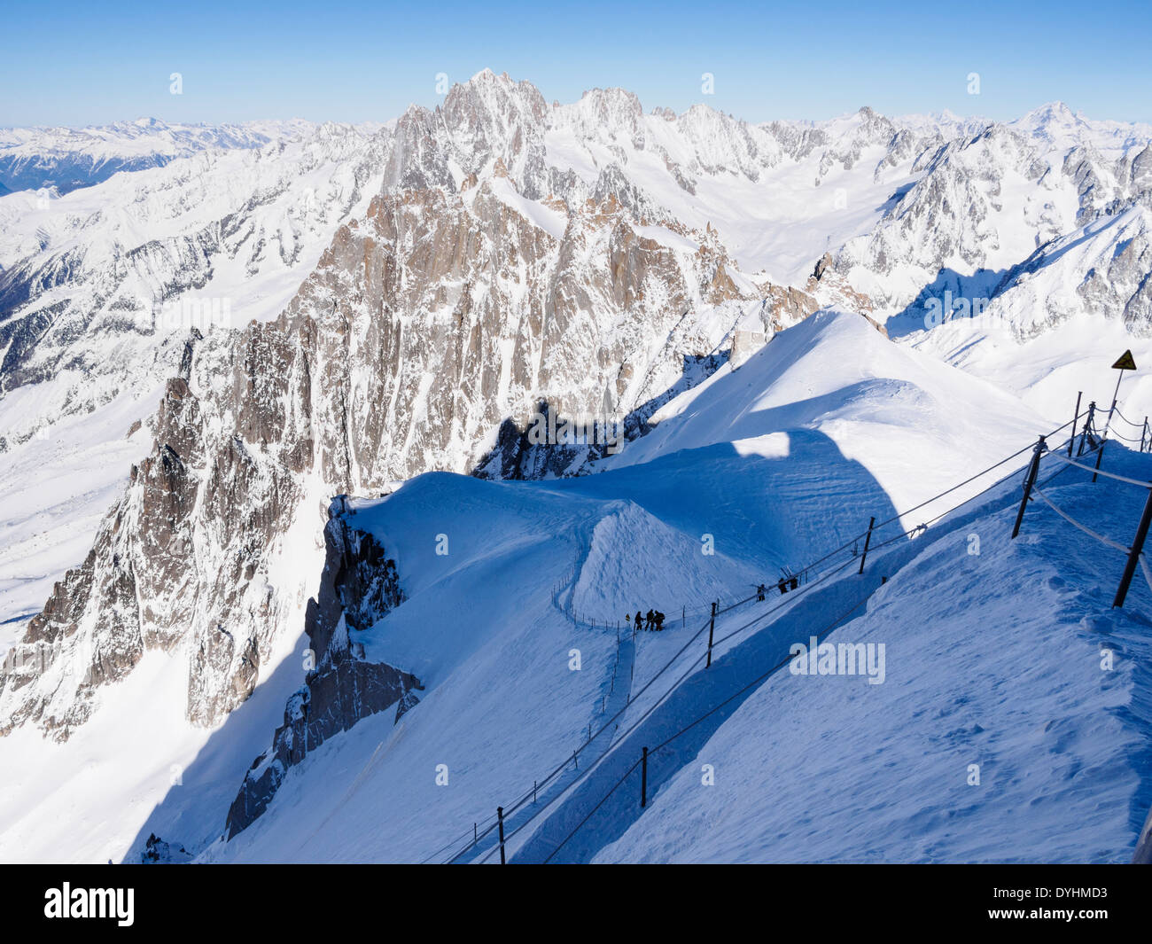Roped path route to Vallee Blanche with skiers descending on Aiguille du Midi. Chamonix-Mont ...