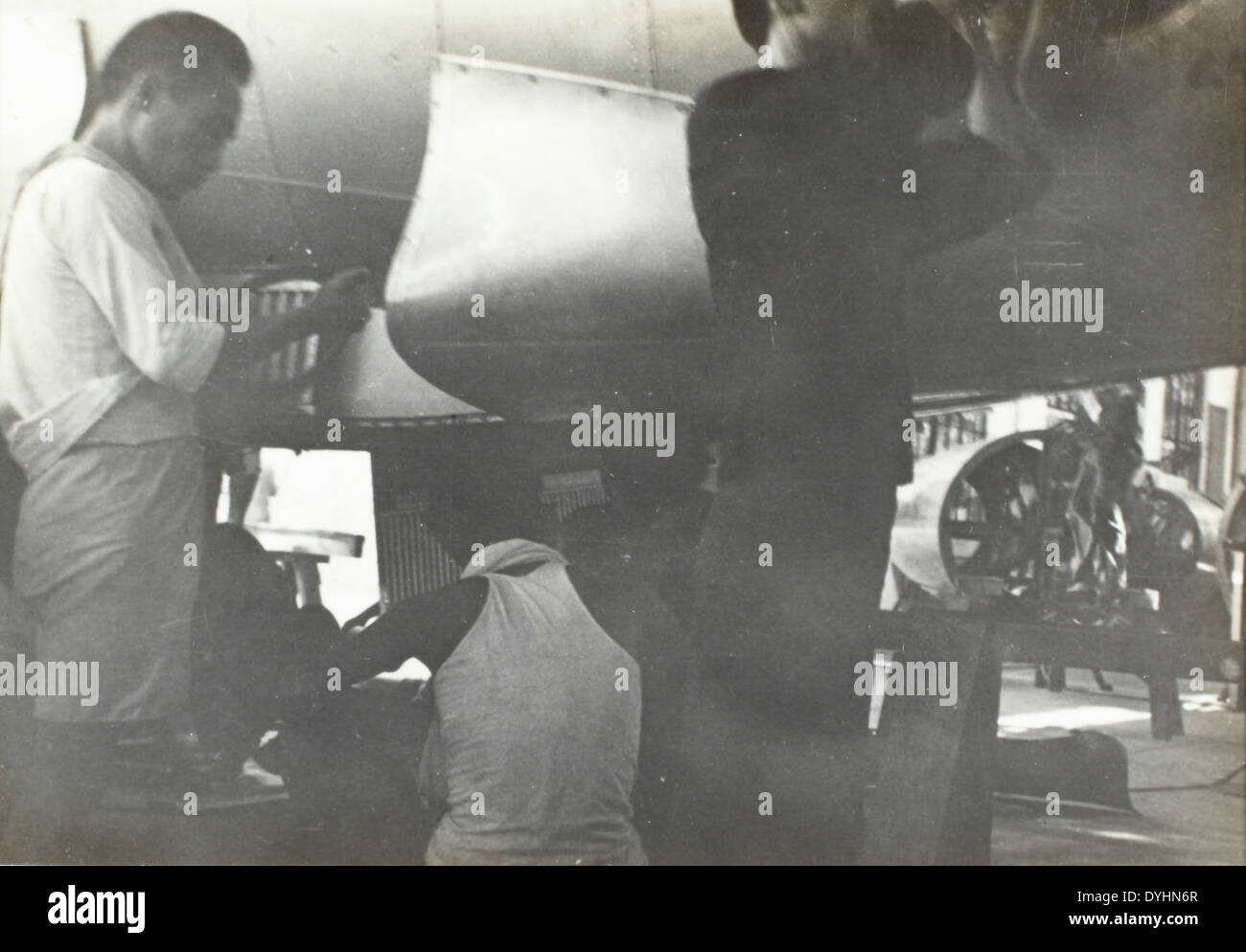 This image captures two factory workers involved in the production of ...