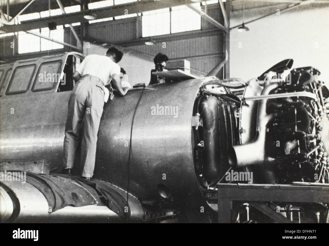 This photograph shows workers assembling an aircraft in a factory ...