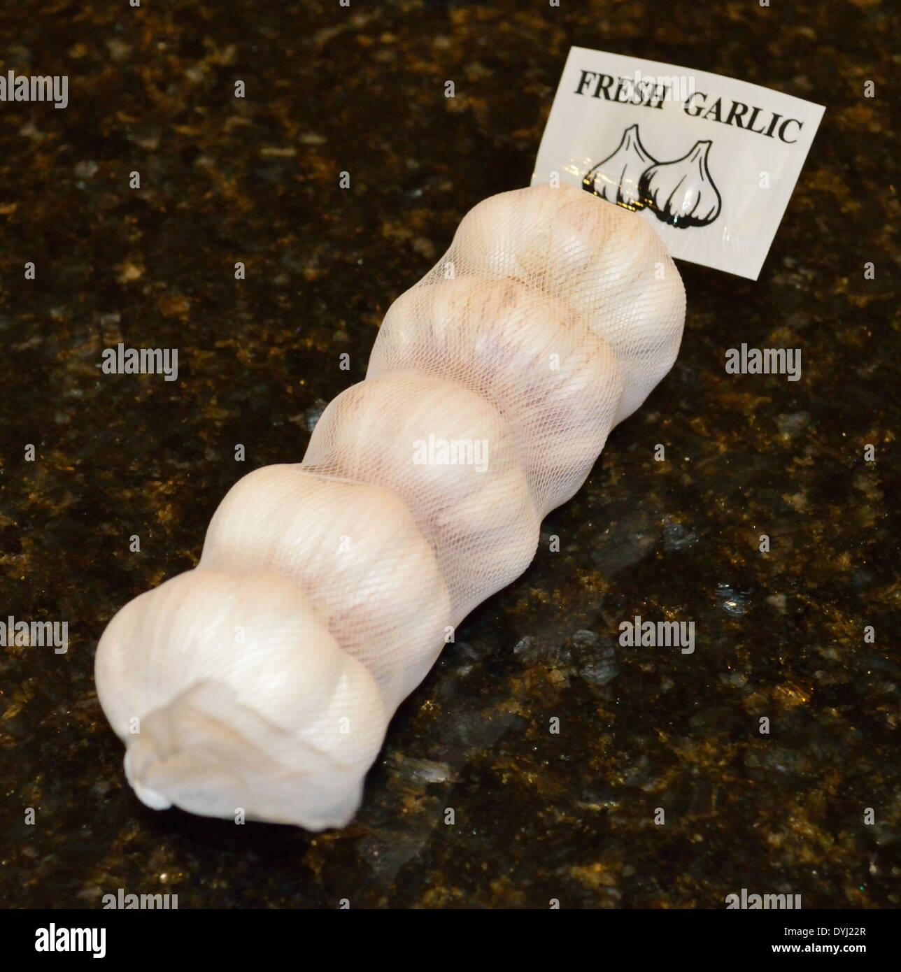 Five whole fresh garlic netted and labeled Stock Photo - Alamy