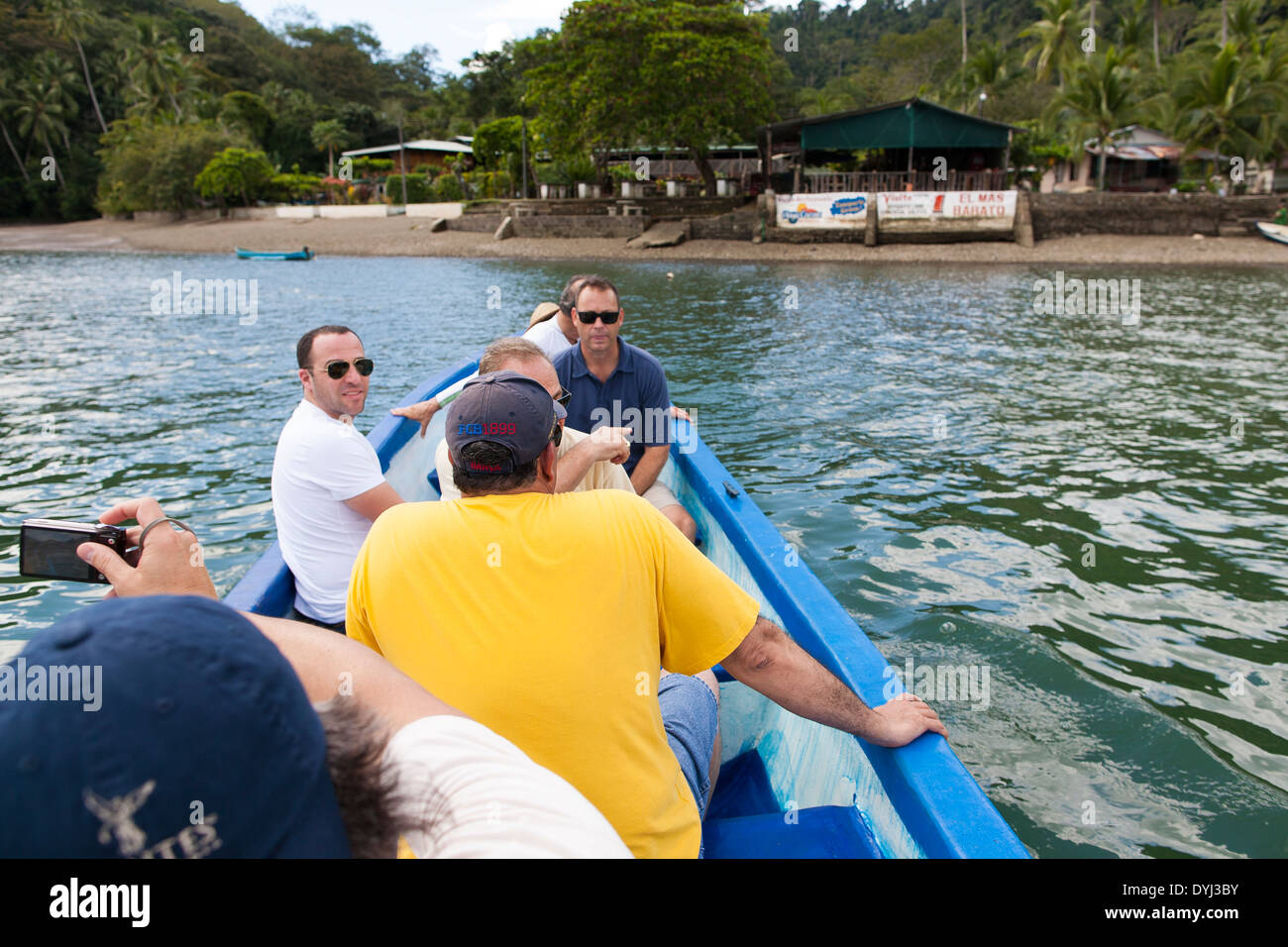 Tourists in a small boat, panga or launch go ashore to eat fresh ...