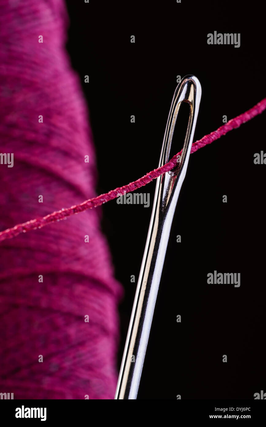 Macro of a needle and a purple roll of elastic thread Stock Photo - Alamy