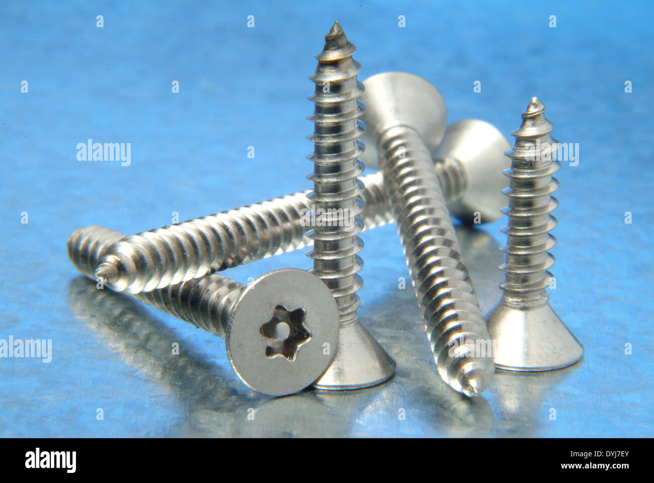 Security screws on light blue background Stock Photo - Alamy
