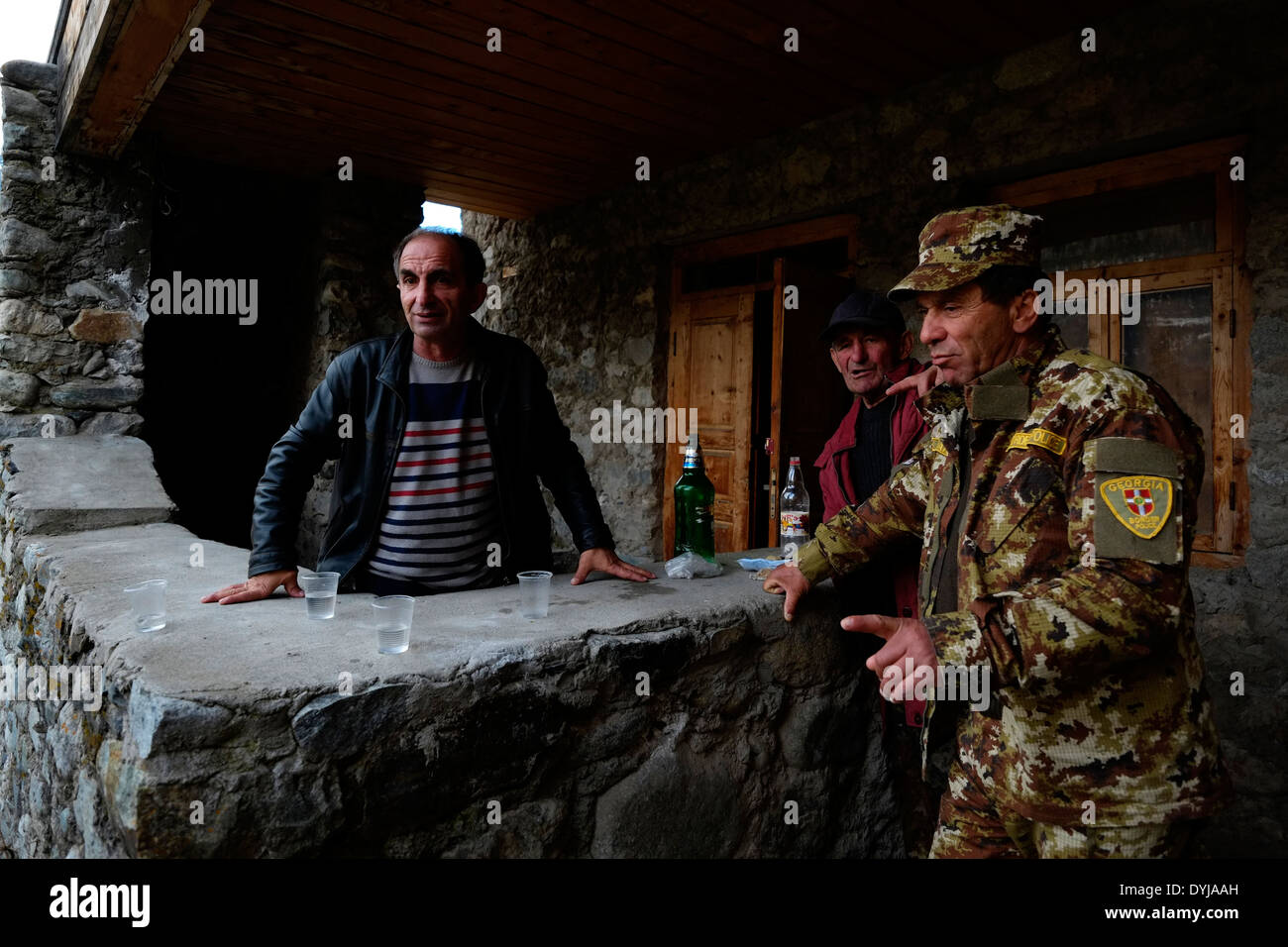 A Georgian border soldier drinking beer with villagers in Mestia a ...