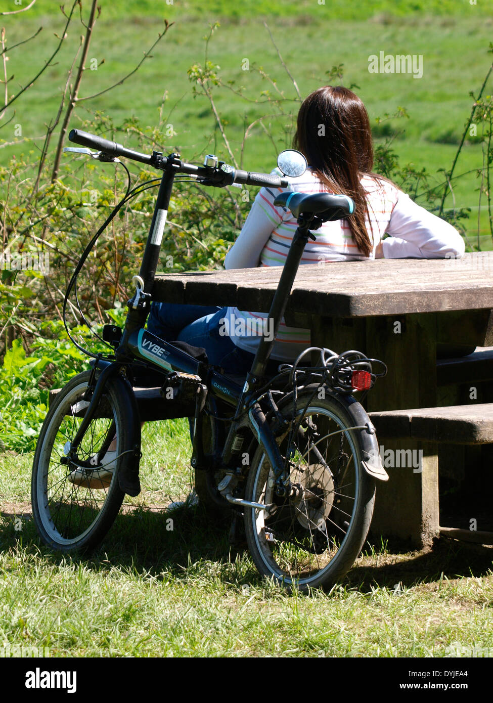 Woman resting on a public bench with a Vybe City Bike, Wadebridge ...
