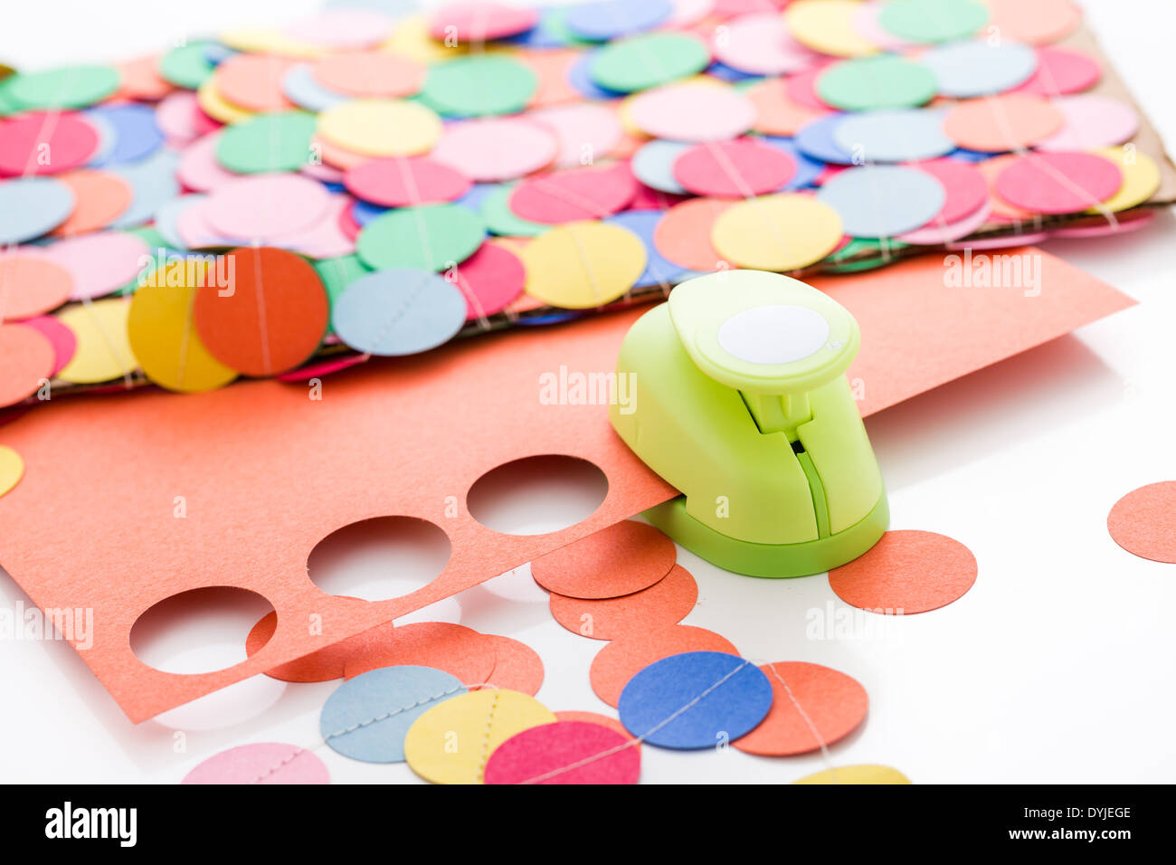 Making a colorful paper garland with reound puncher Stock Photo - Alamy