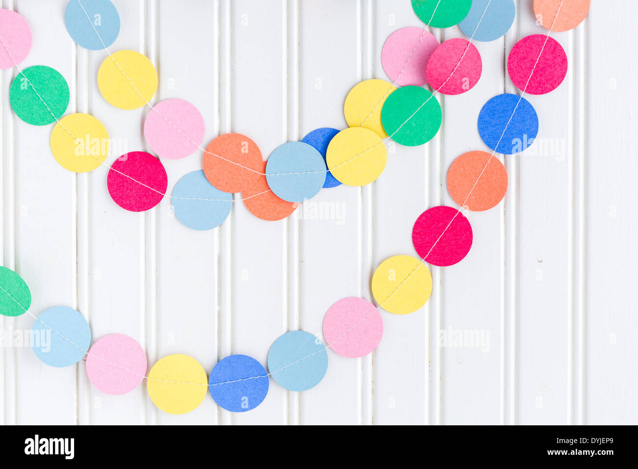 Making a colorful paper garland with reound puncher Stock Photo - Alamy