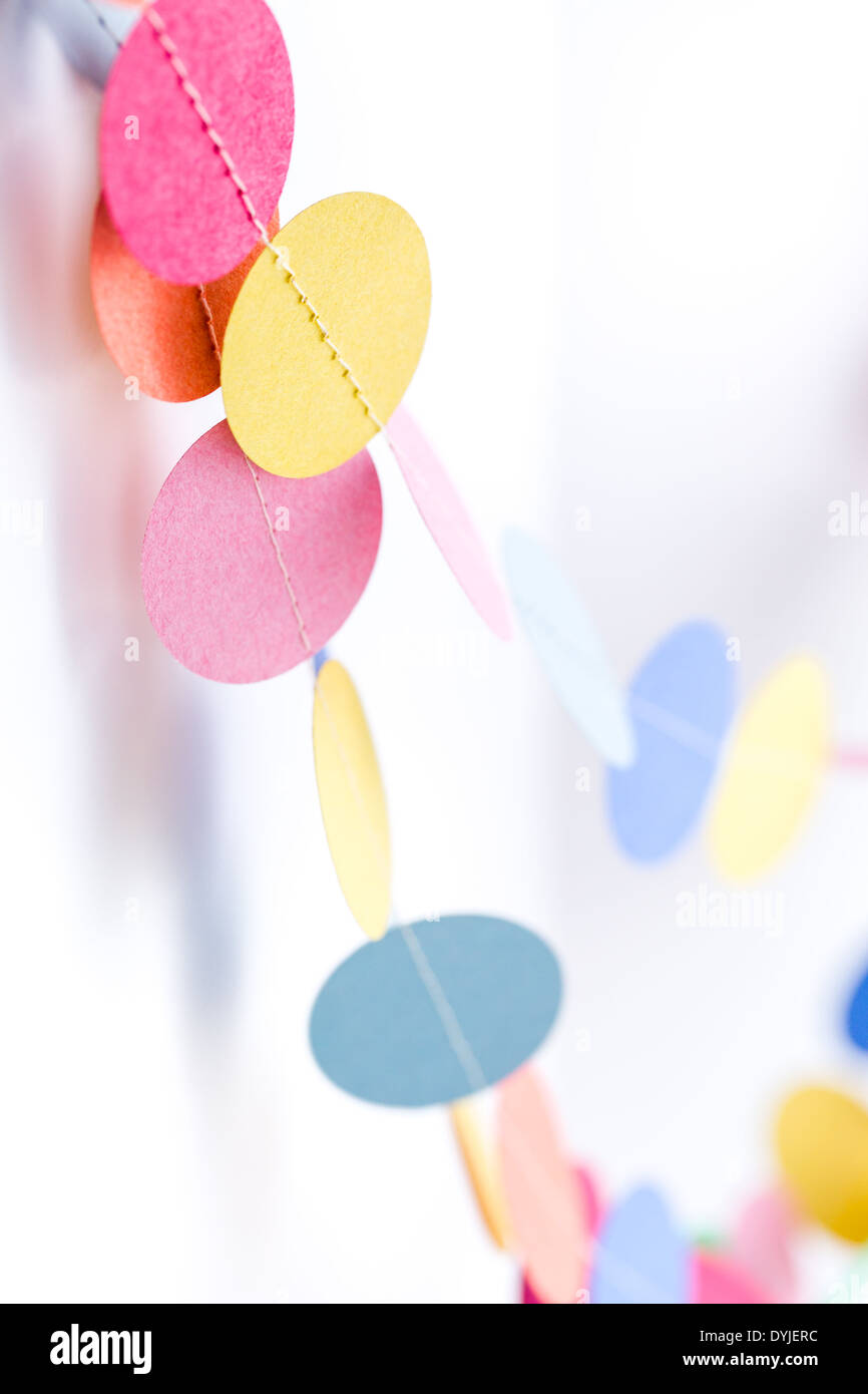 Making a colorful paper garland with reound puncher Stock Photo - Alamy