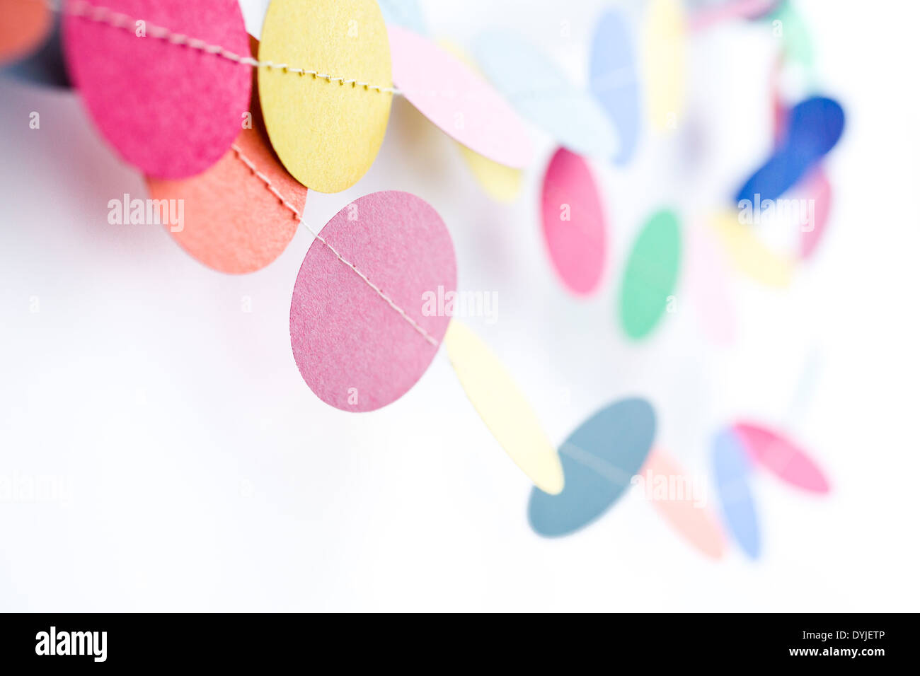 Making a colorful paper garland with reound puncher Stock Photo - Alamy