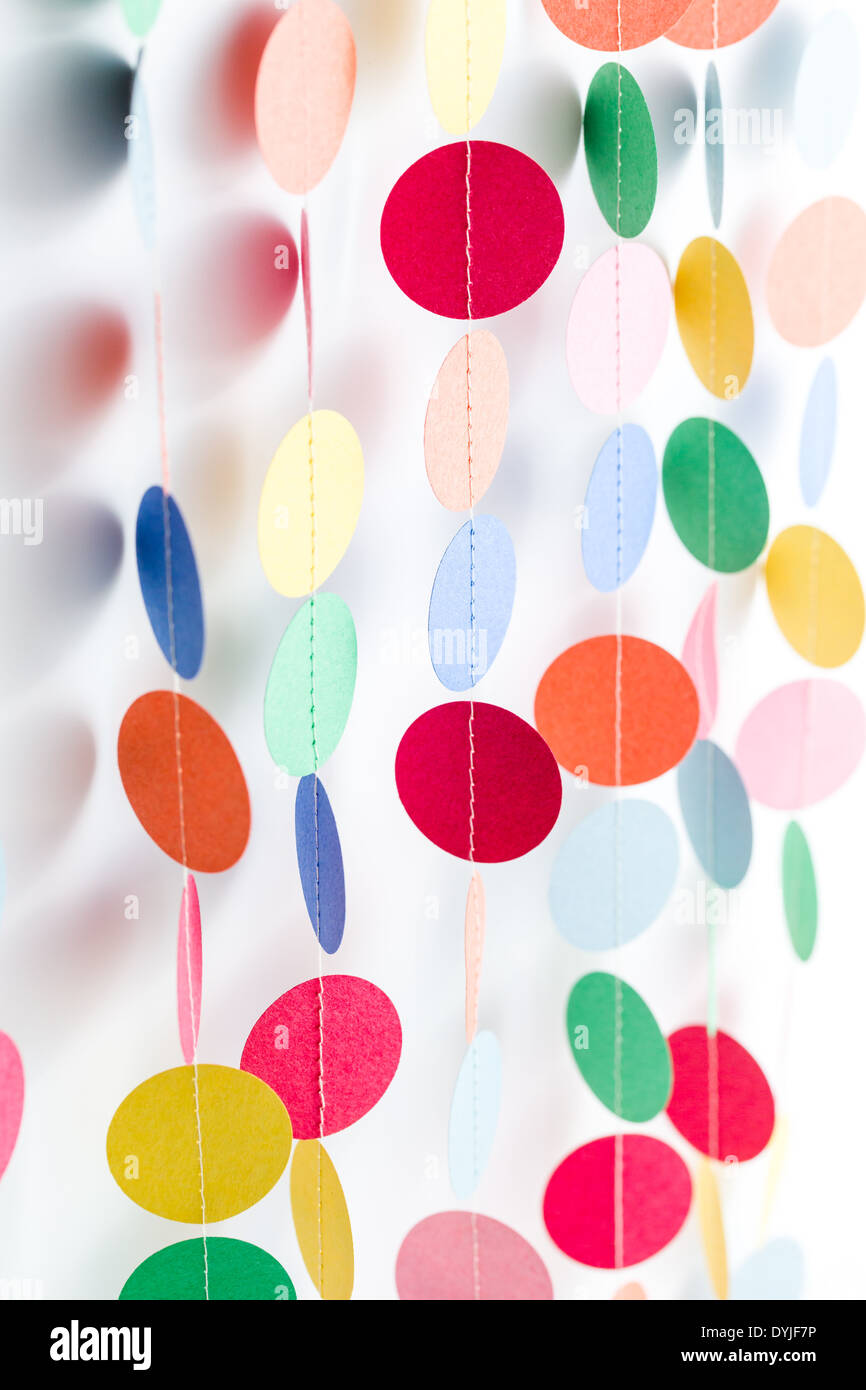 Making a colorful paper garland with reound puncher Stock Photo - Alamy