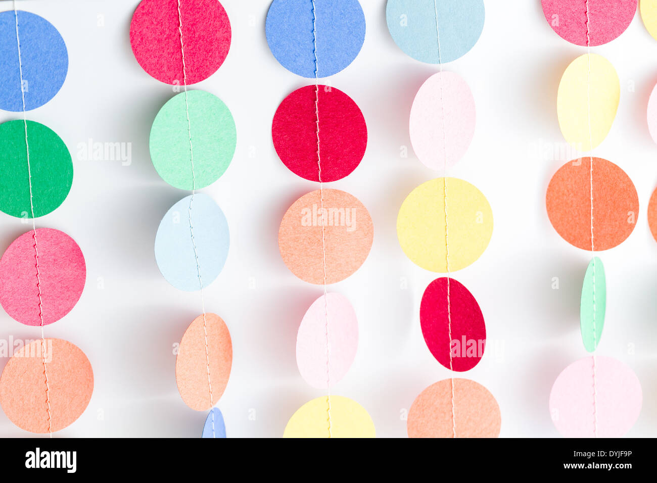 Making a colorful paper garland with reound puncher Stock Photo - Alamy