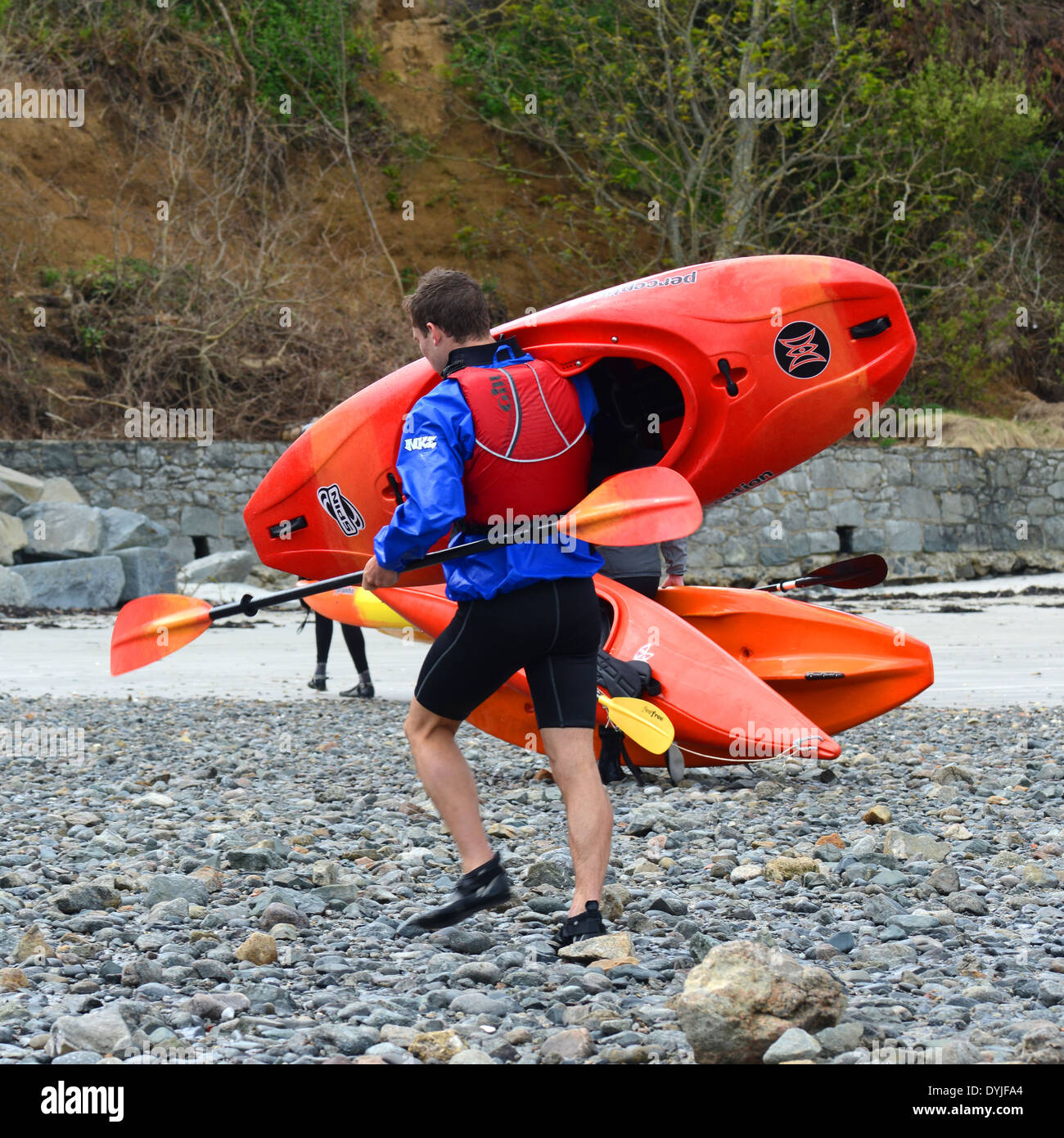 A man carrying a sea kayak Stock Photo - Alamy