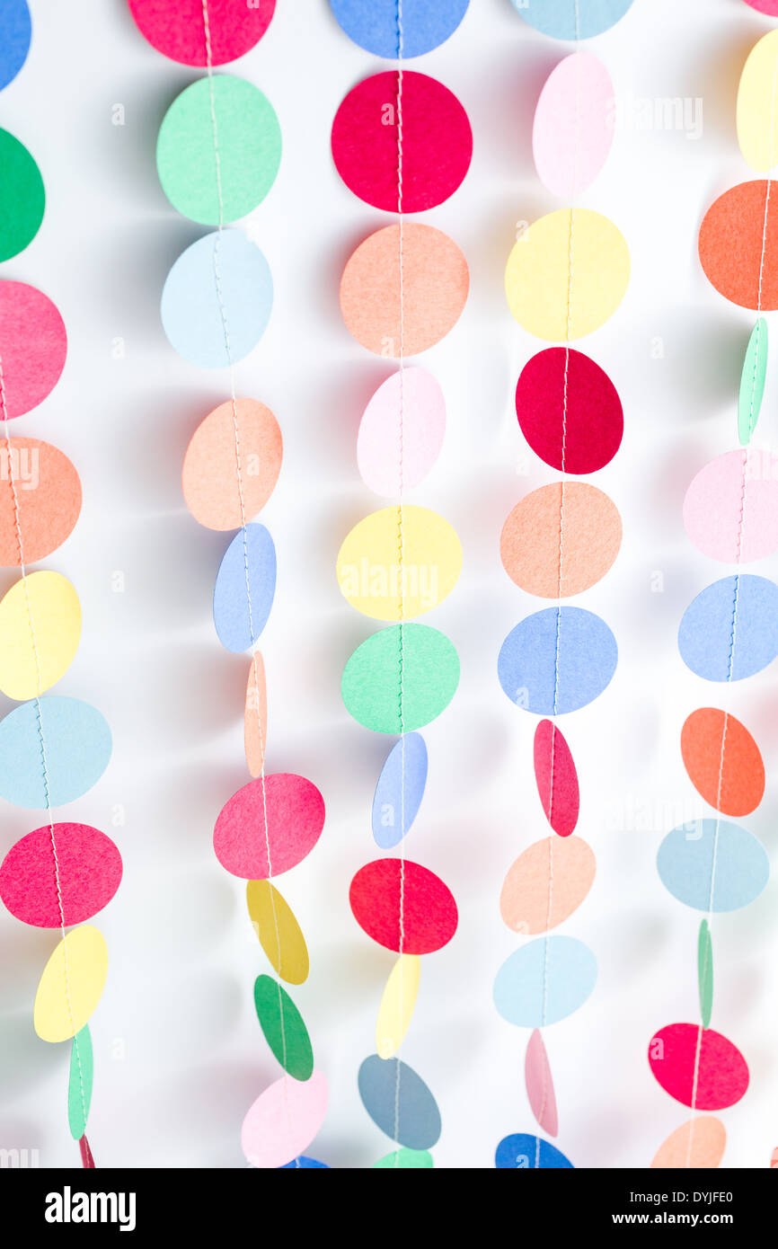 Making a colorful paper garland with reound puncher Stock Photo - Alamy