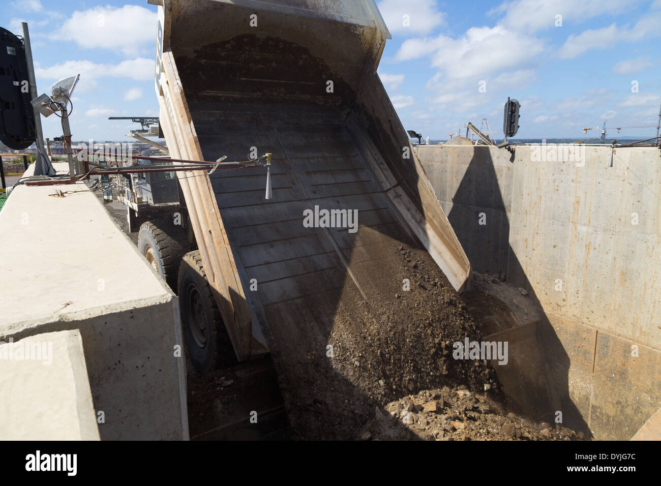 A massive Hitatchi Diesel/ Electric hybrid mining truck dumping rock ...