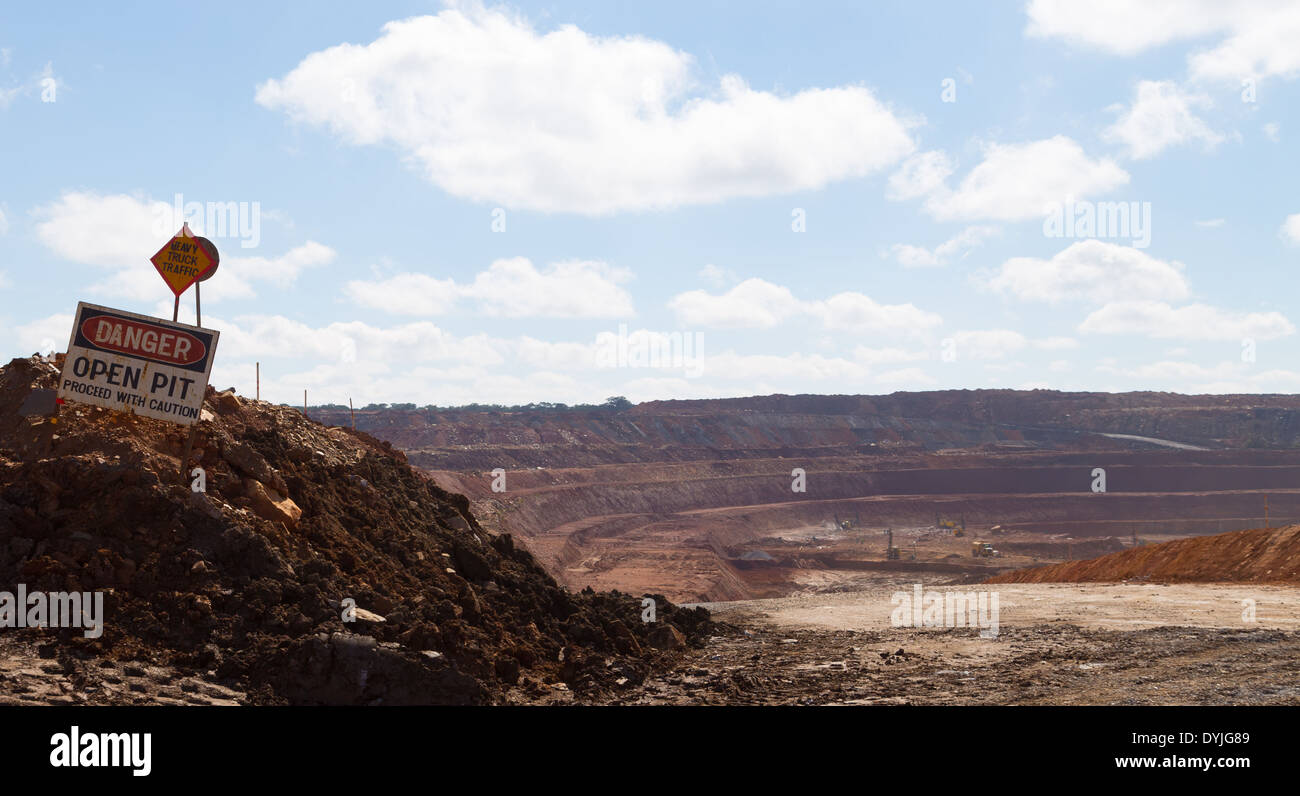 A warning sign at the entrance to a massive open cast copper mine in ...