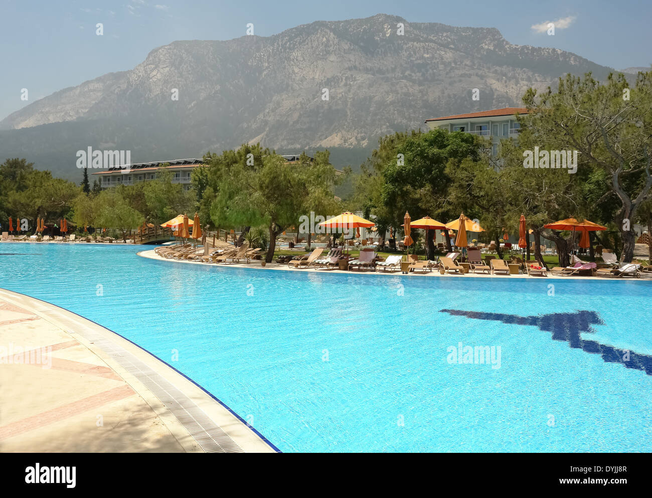 Swimming pool, umbrellas and mouintains in modern high class hotel of ...