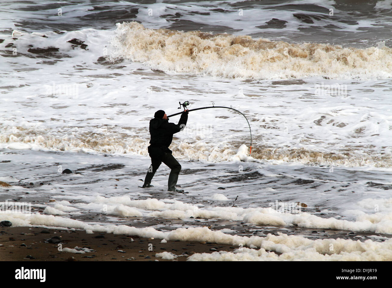 Beach angler in action Stock Photo - Alamy