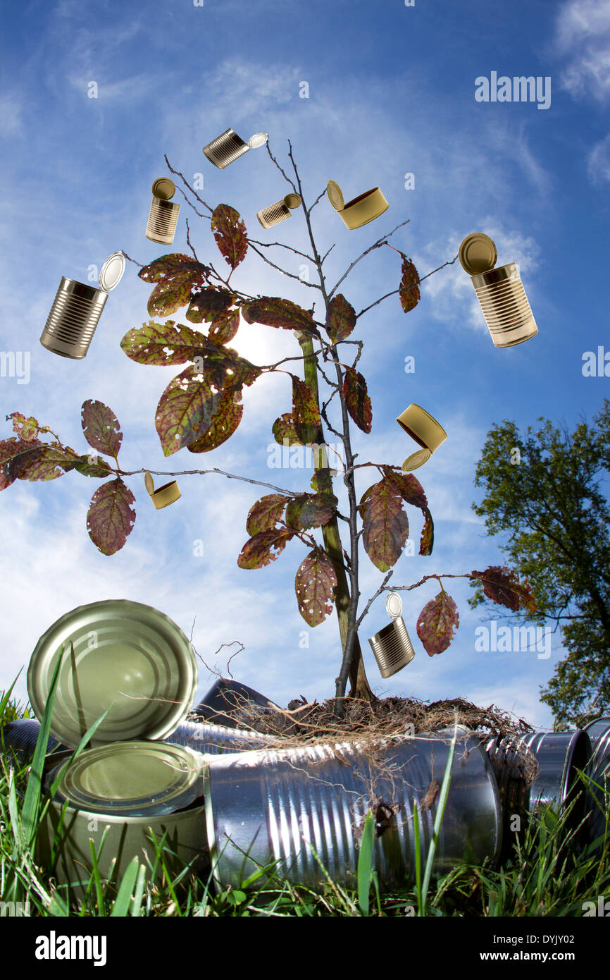 Recycling concept illustrated with a stack of empty tin cans growing a ...