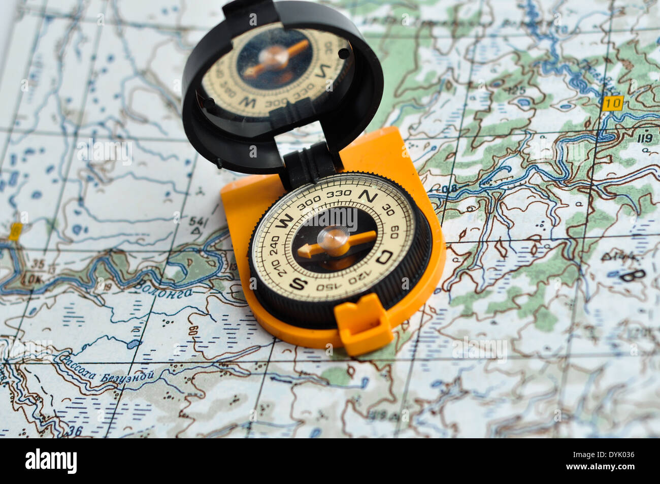 Outdoor compass in orange body with black lid and a mirror in it is ...