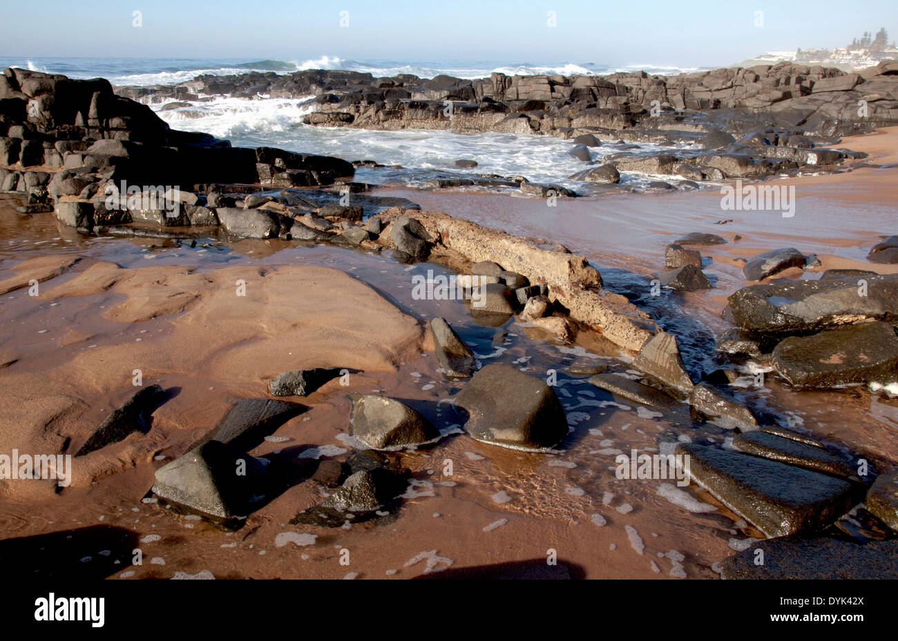 incoming wave forming pools on rocky beach at Ballito north of Durban ...