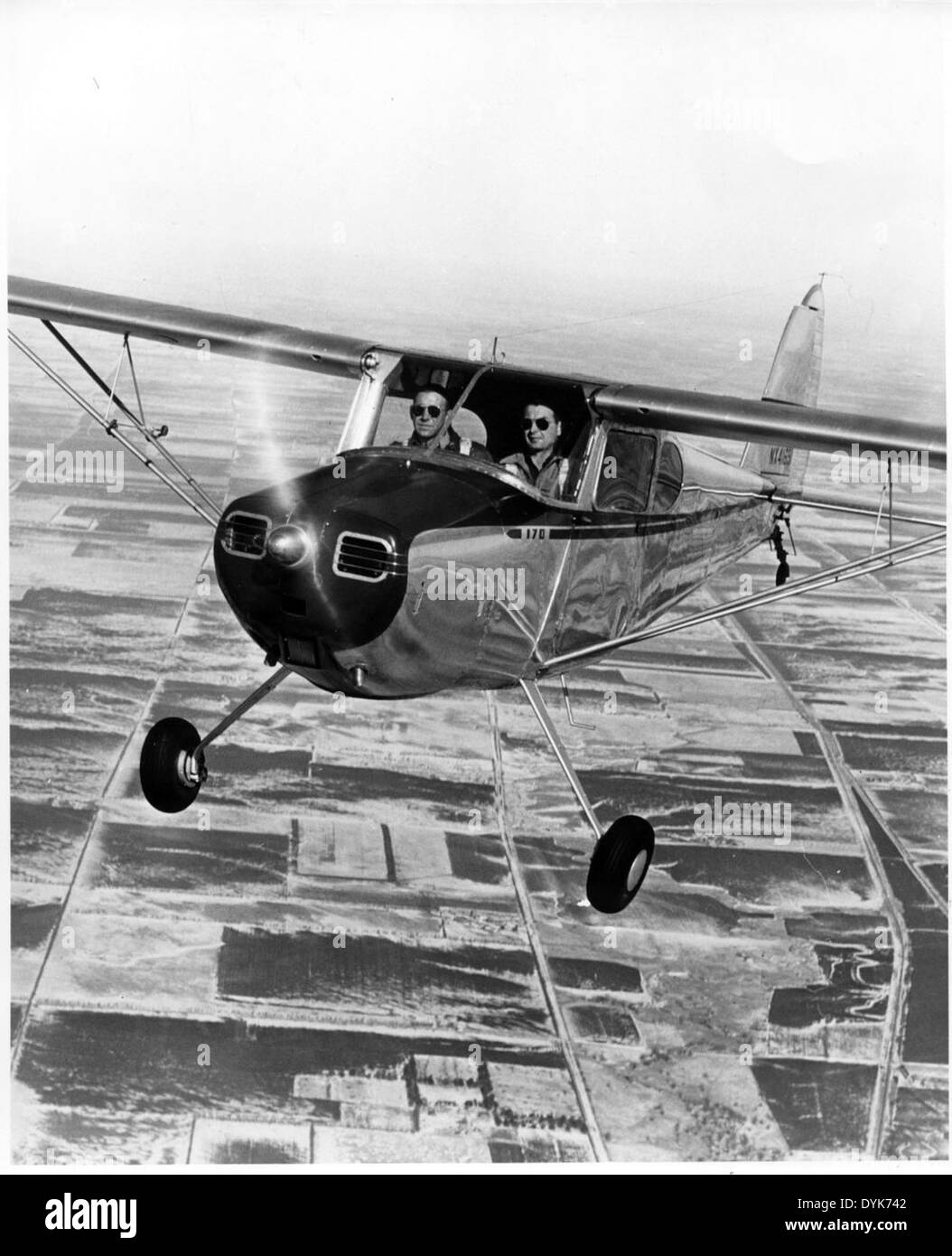 This photograph features Hank Waring flying a Cessna aircraft as part ...