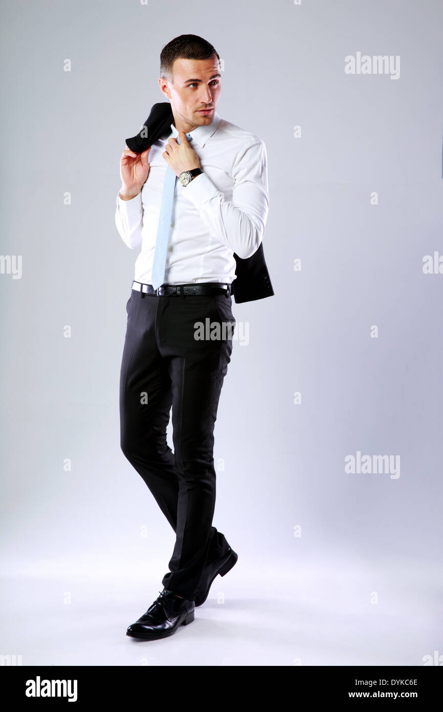 Full length portrait of a pensive business man holding jacket on ...