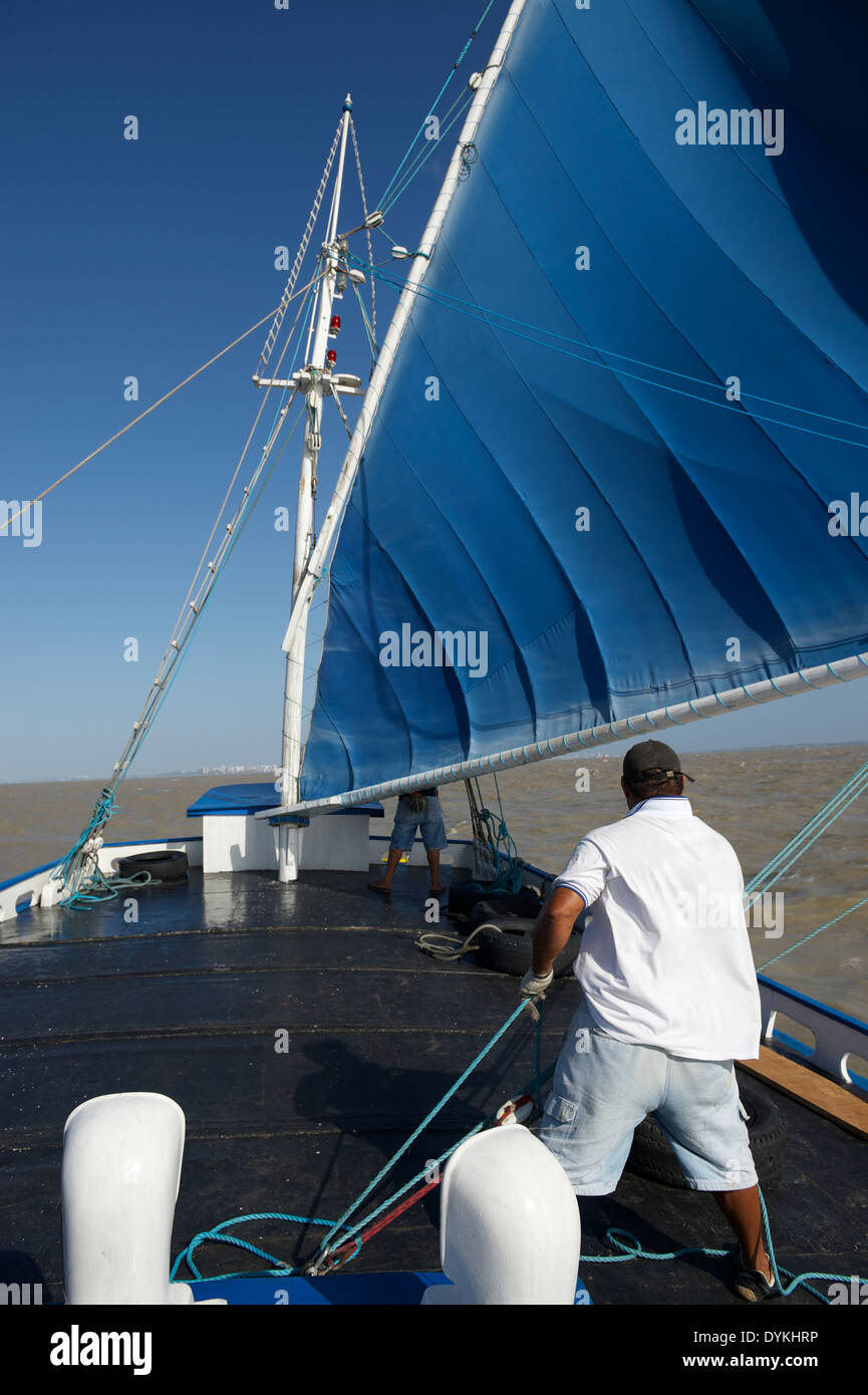 Sailboat with blue sails sailing on turbulent waters in Nordeste Brazil ...