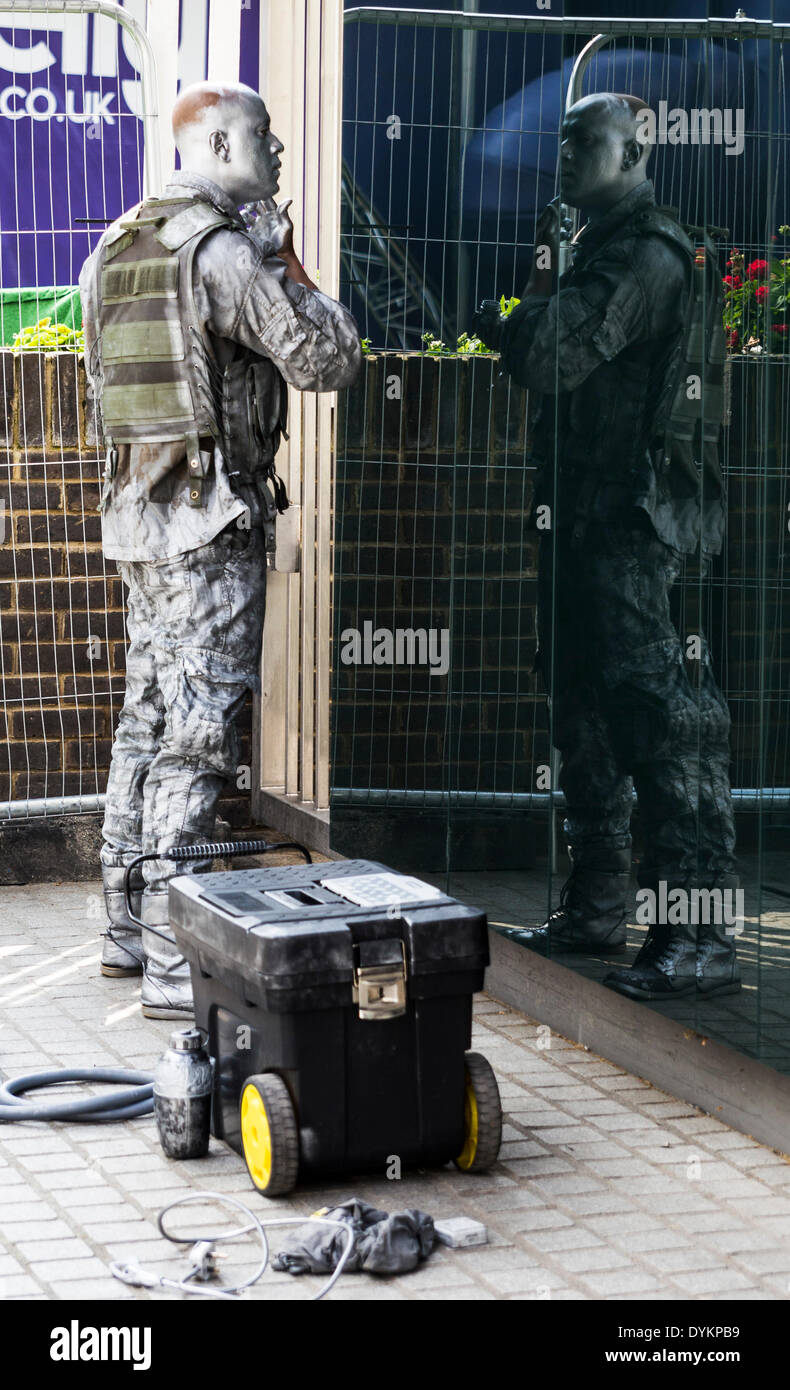 London, UK. 21st Apr, 2014. Busker getting dressed before performing ...
