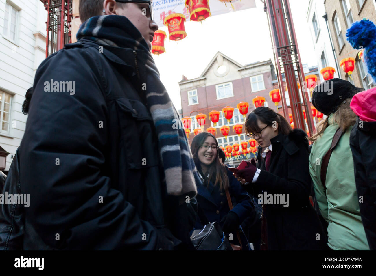 Two Asian teenagers sending a text message Stock Photo - Alamy