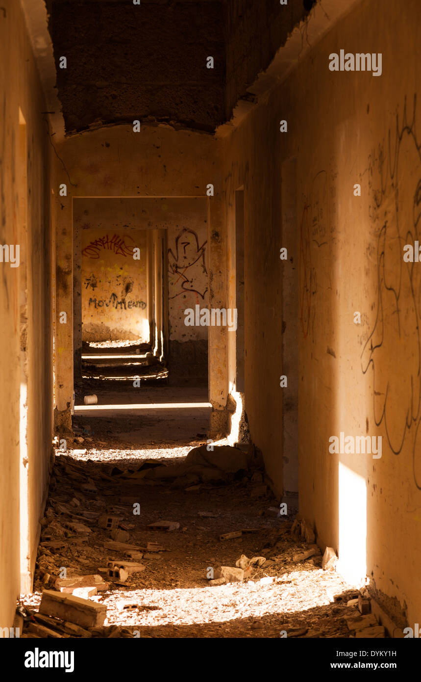 View down a derelict corridor with light coming in from openings Stock ...