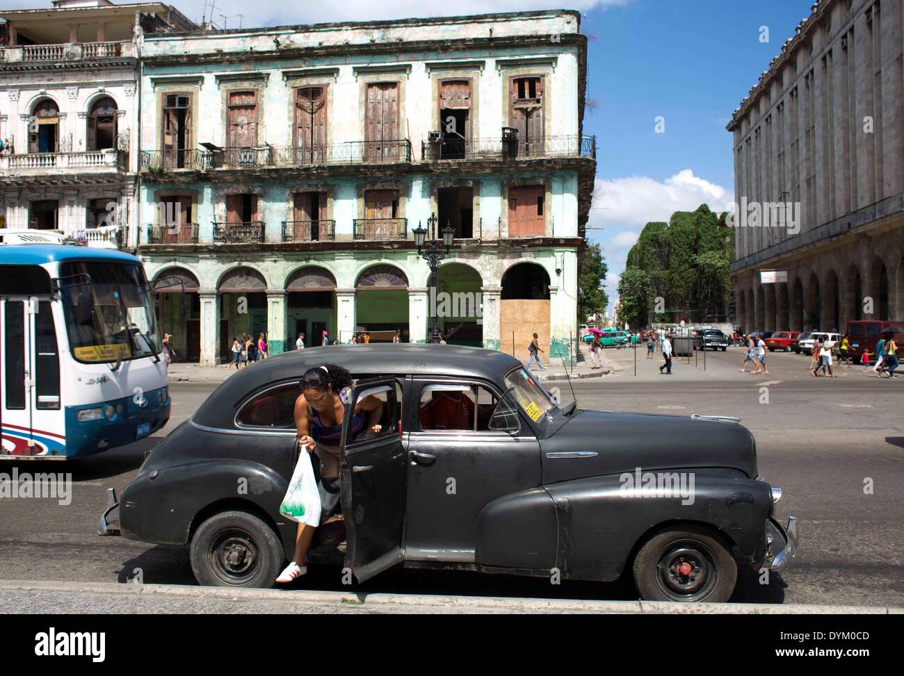 Havana, Cuba. 21st Apr, 2014. A Cuban citizen descends from a classic ...