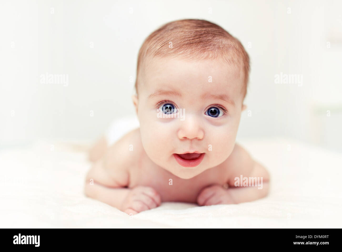 Baby with blue eyes looking into camera smiling Stock Photo - Alamy