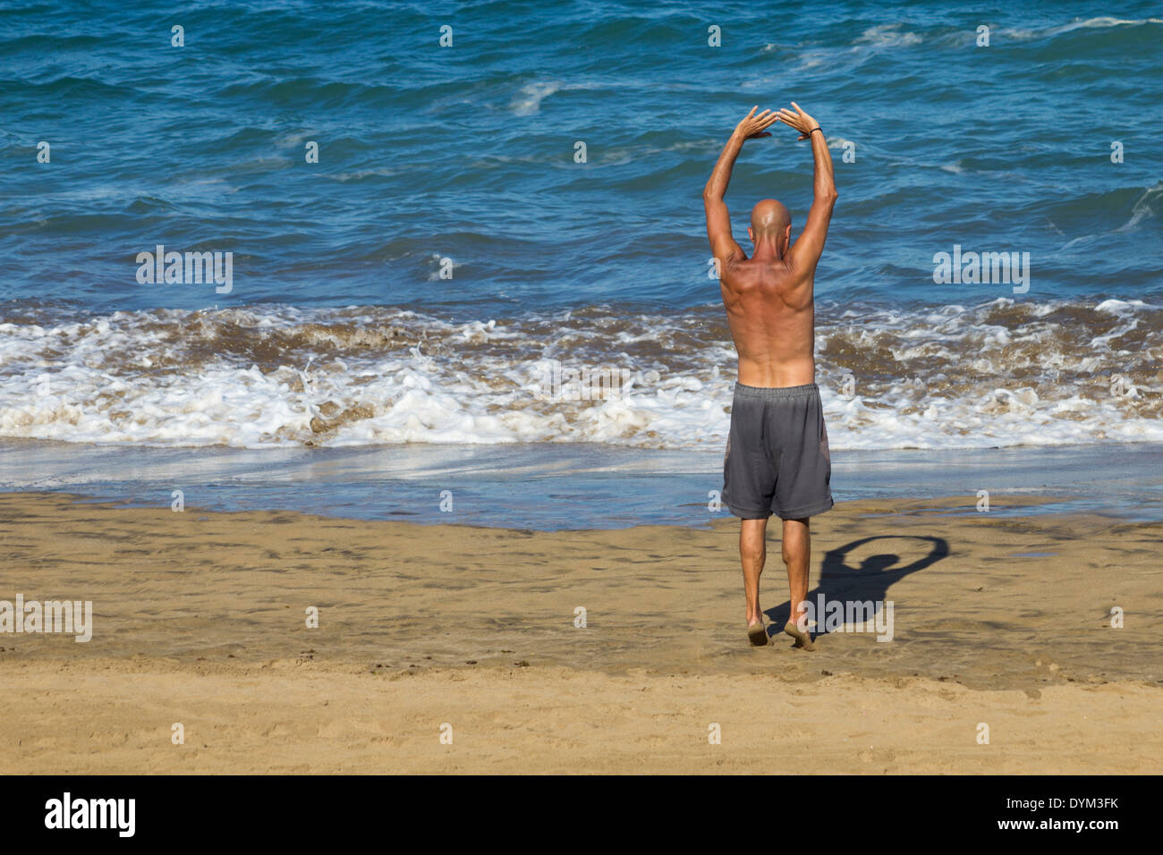 Man stretching on beach Stock Photo - Alamy