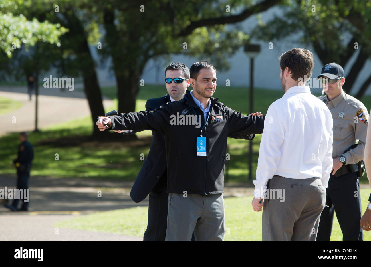 Security team uses metal detector wand on people and media attending ...