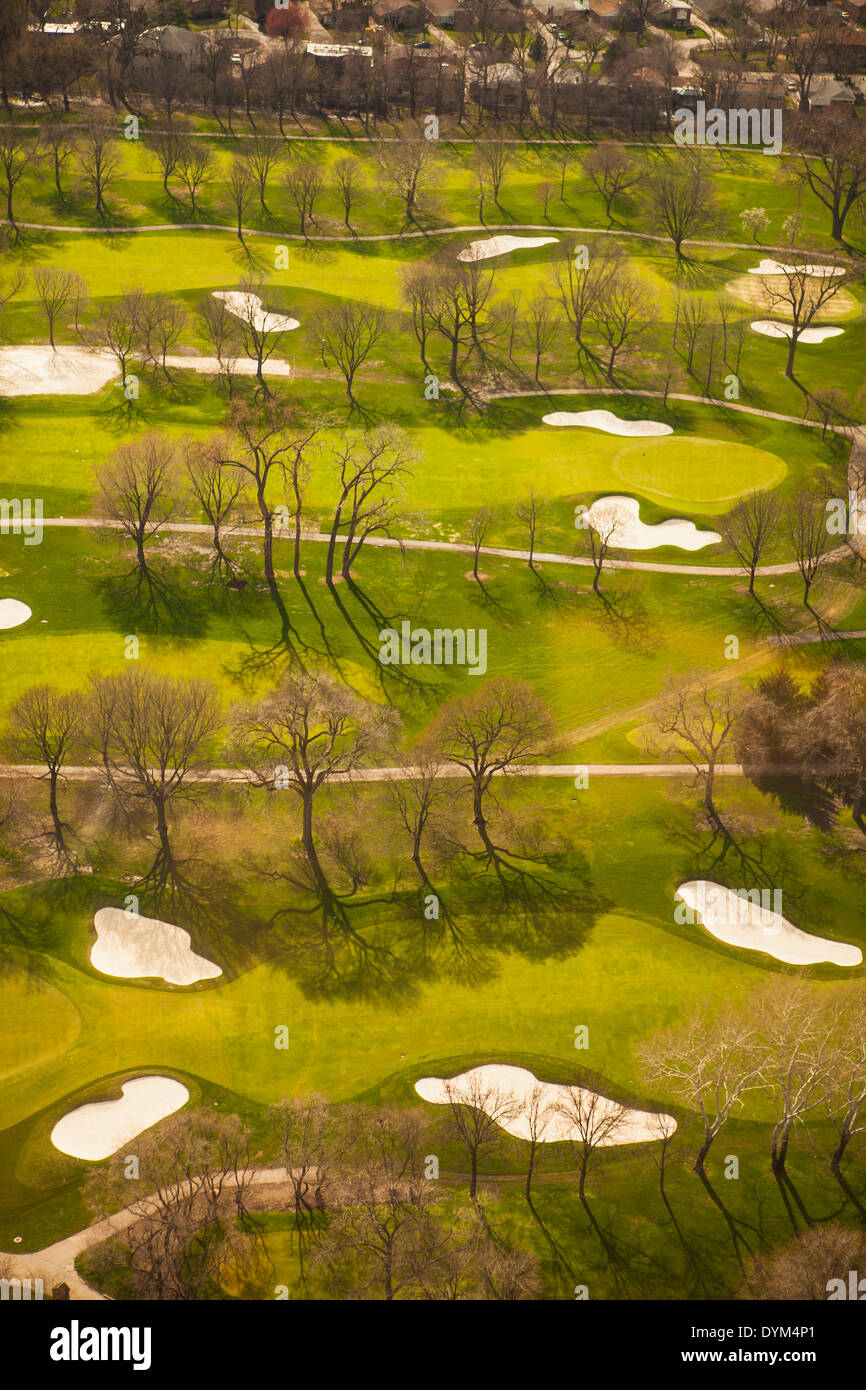 bare, spring trees throw shadows on a golf course near Chicago ...