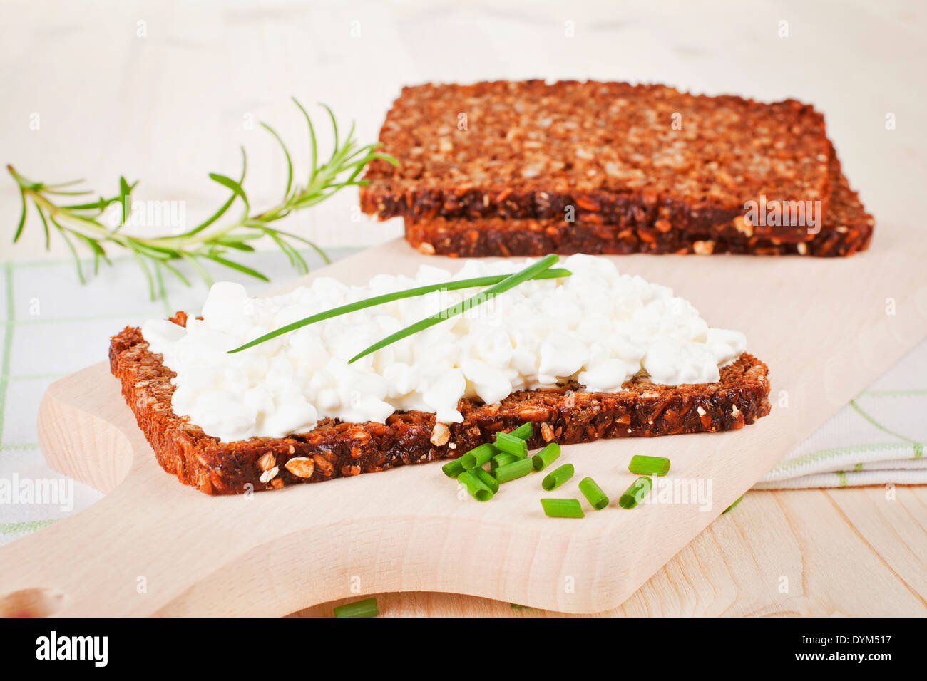 Black whole wheat bread slices with cottage cheese, fresh herbs and ...