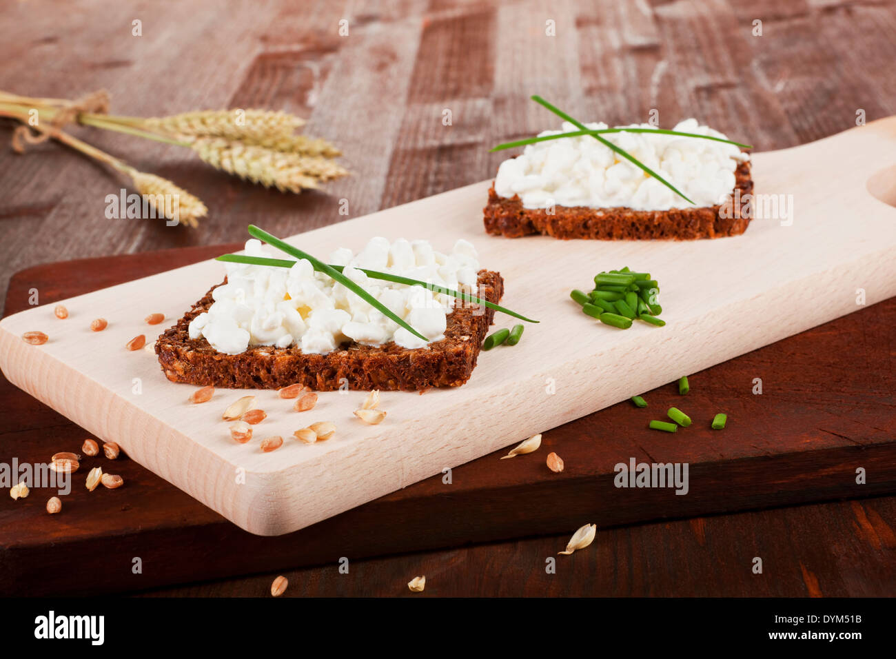 Black whole wheat bread slices with cottage cheese, fresh herbs and ...