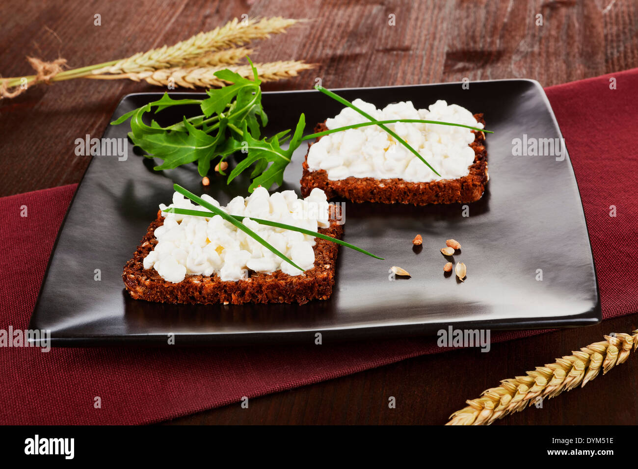 Black whole wheat bread slices with cottage cheese, fresh herbs and ...