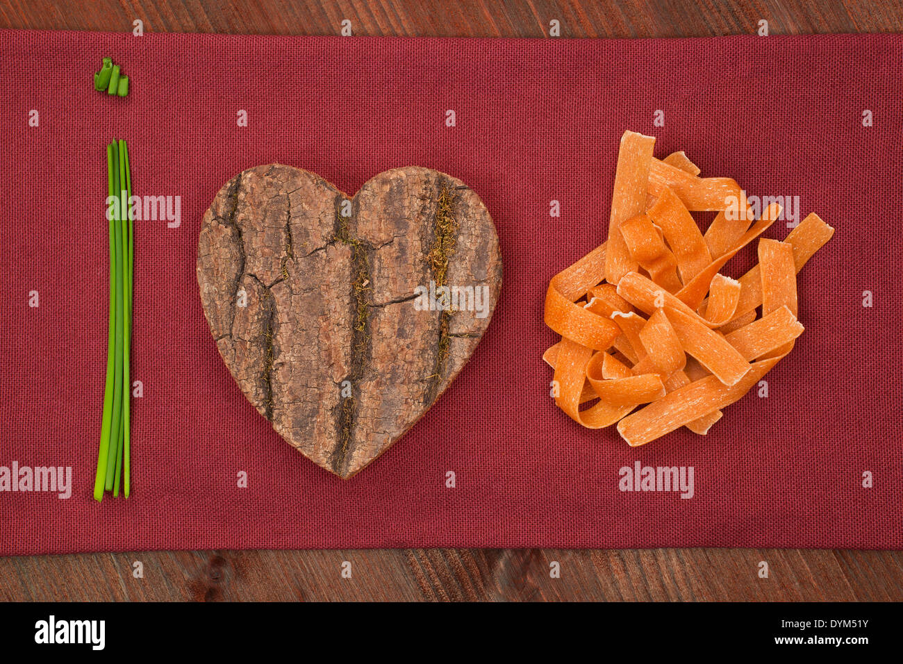 I love pasta made of chive, wooden heart and pasta on burgundy cloth ...