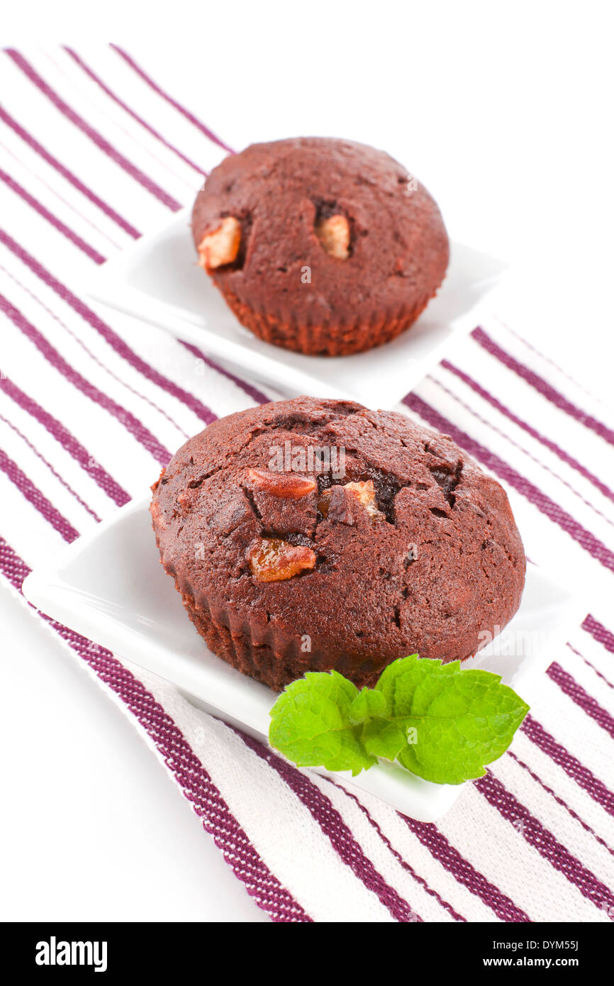 Luxurious chocolate muffins decorated with fresh mint leaf in white ...