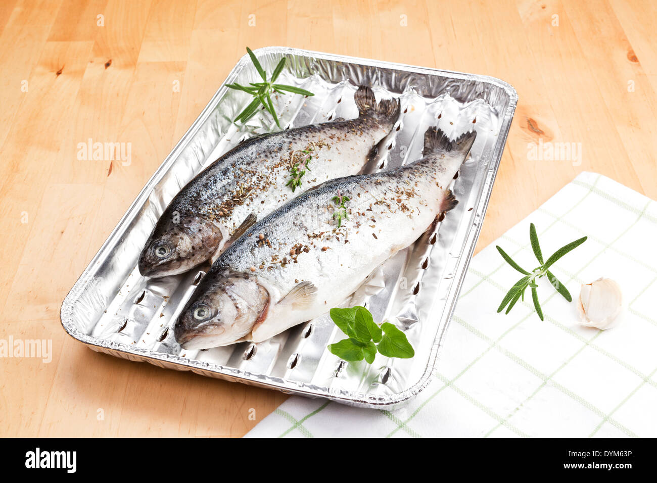 Two silver fish fillet prepared for grill on aluminium tray. Healthy ...