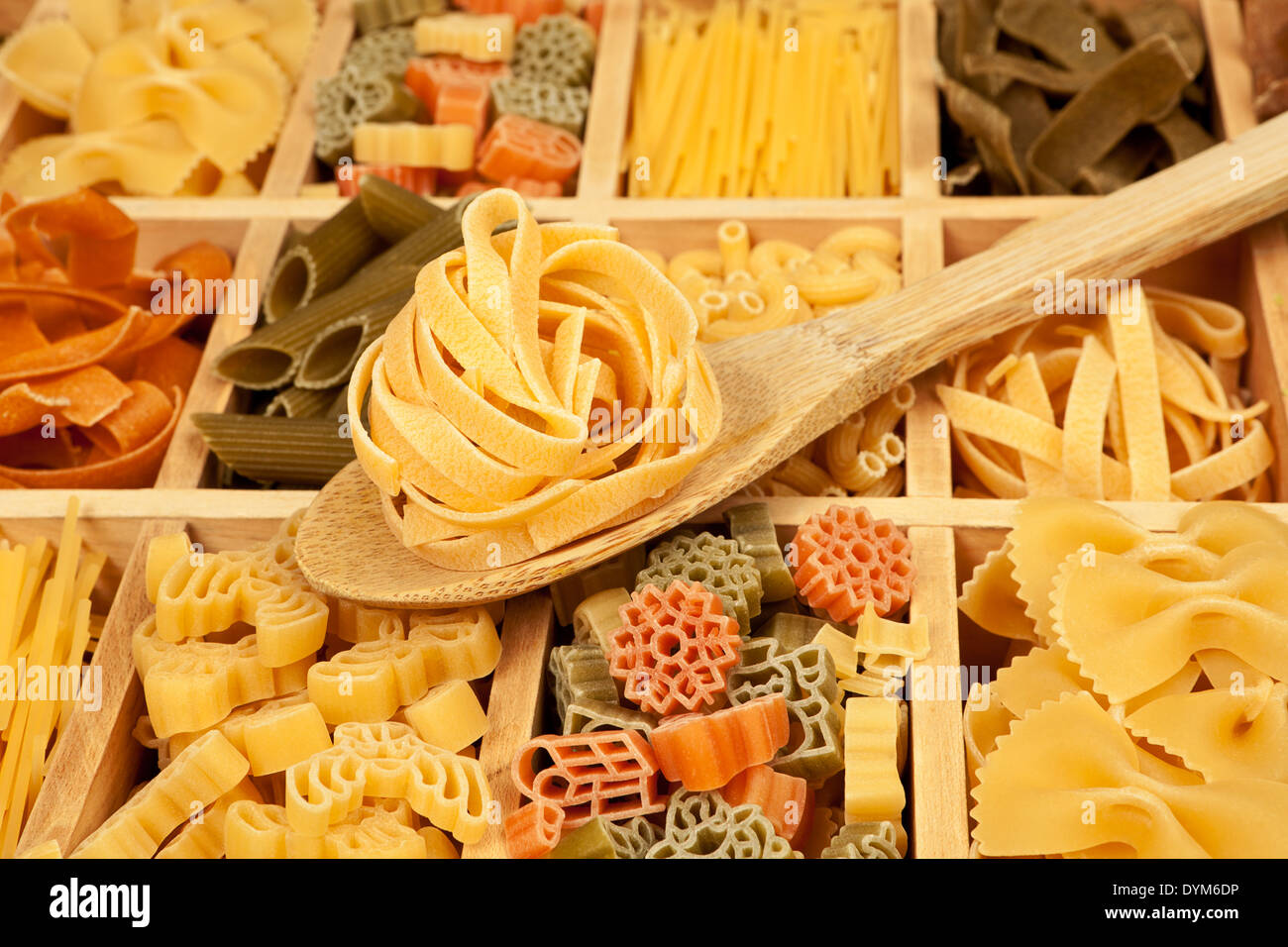 Pasta variation - different pasta sorts in wooden box with wooden spoon ...