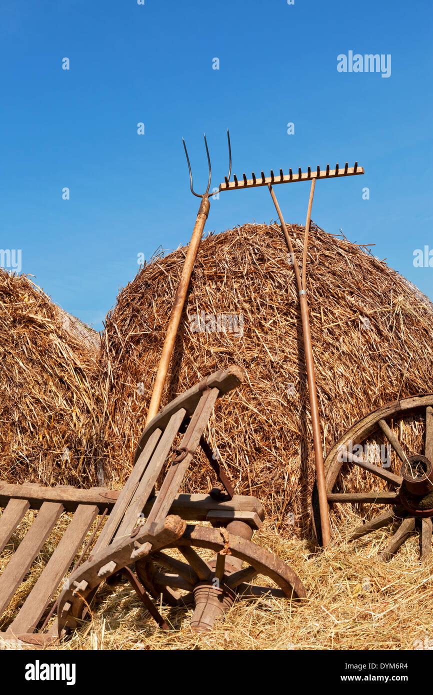 Traditional agriculture background. Hay bales, wooden wheel and wooden ...
