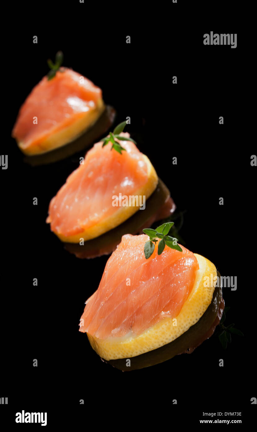 Luxurious seafood canape. Smoked salmon on lemon slices isolated on ...